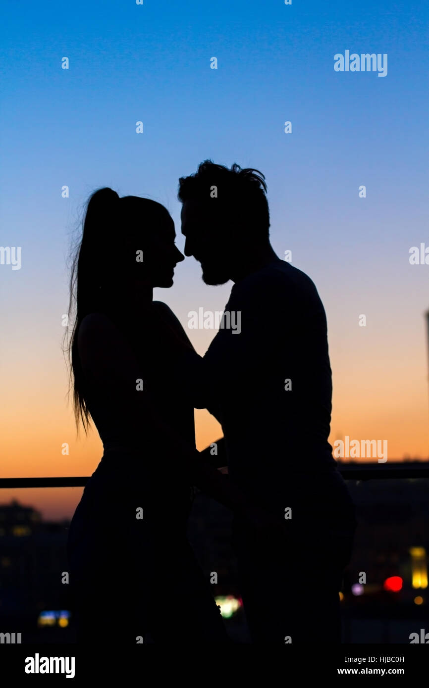Couple and evening sky background Stock Photo - Alamy