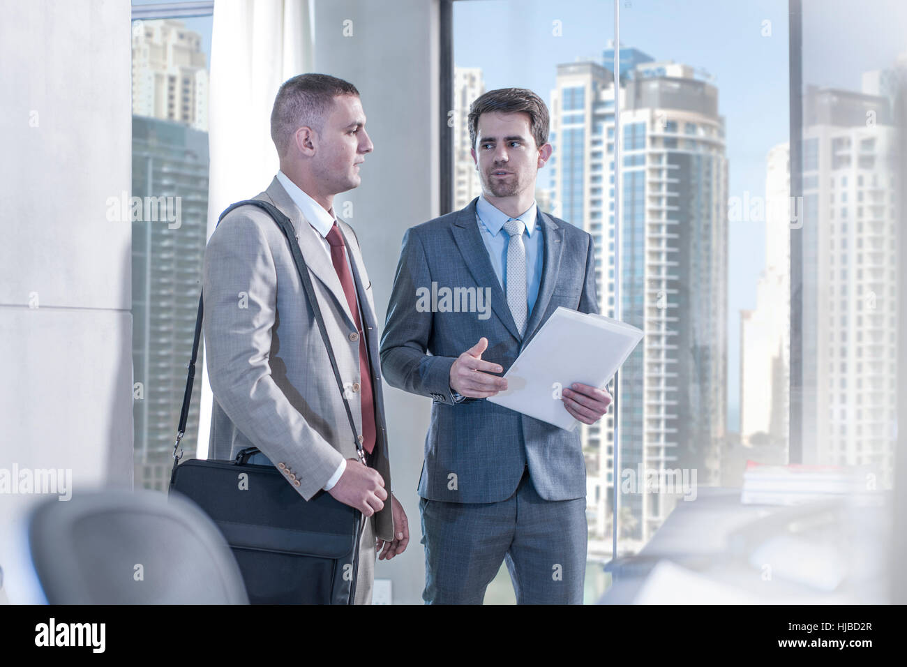 Two businessmen arriving in conference room with paperwork Stock Photo ...