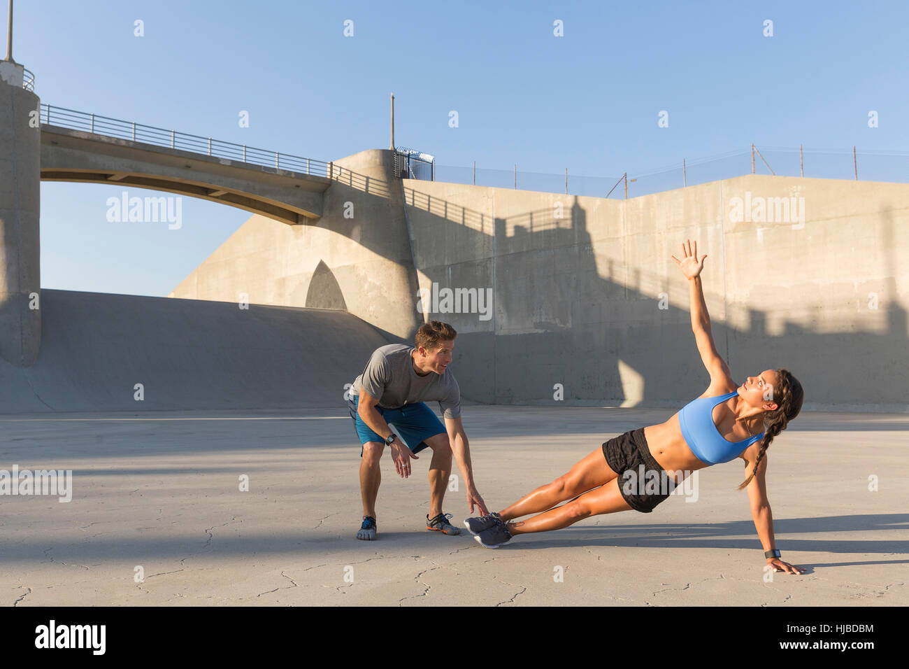 Male athlete helping friend with workout, Van Nuys, California, USA ...