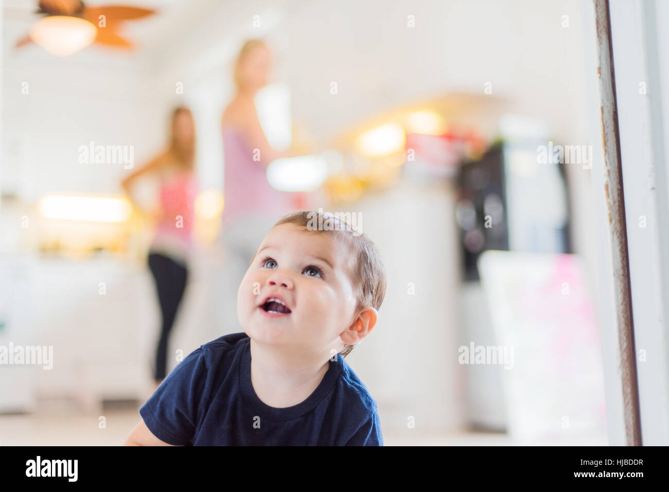Toddler looking up, people in background Stock Photo - Alamy