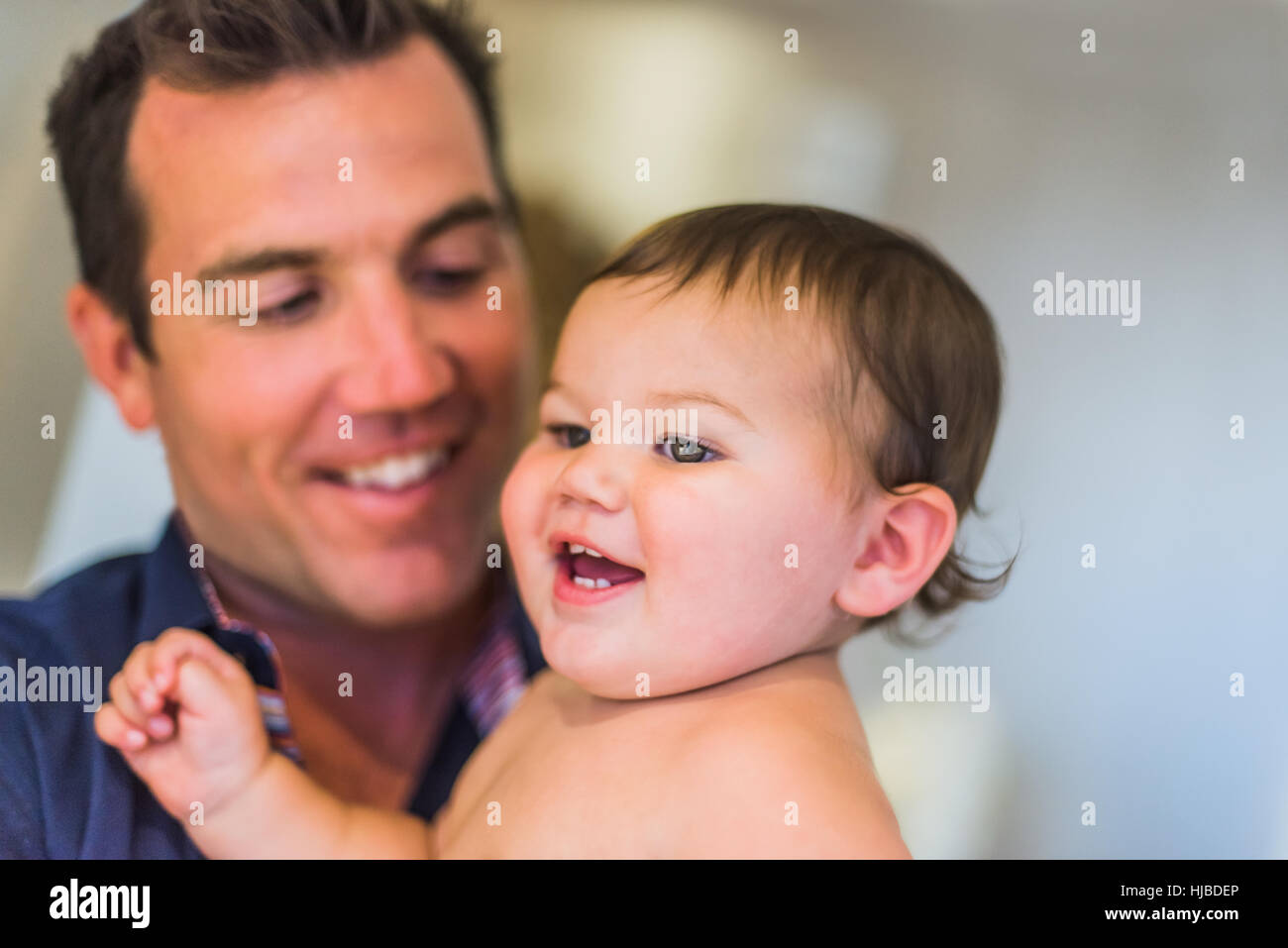Father laughing with son in arms Stock Photo - Alamy