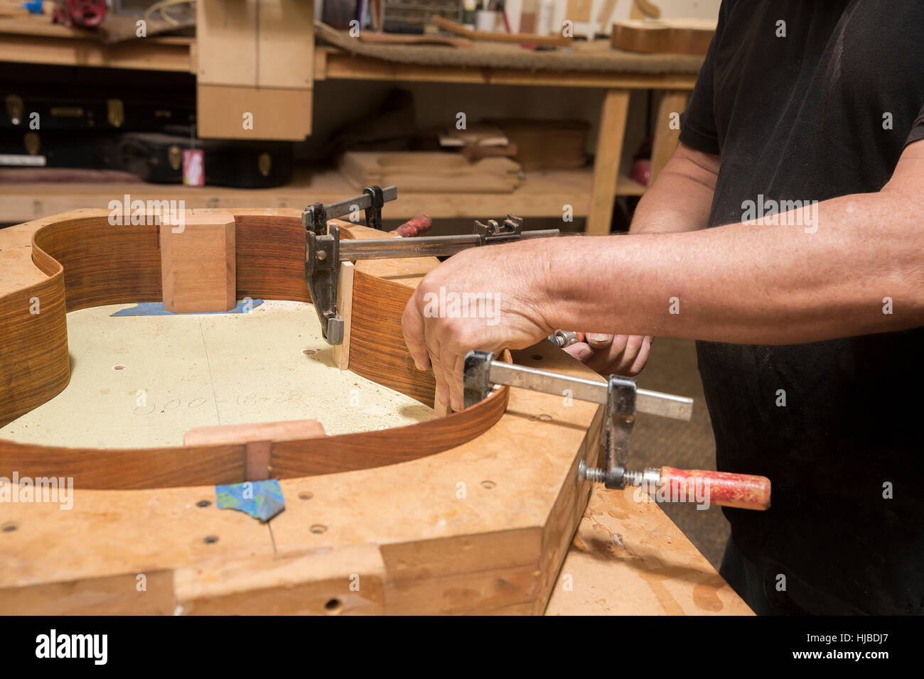Guitar maker in workshop manufacturing guitar Stock Photo - Alamy