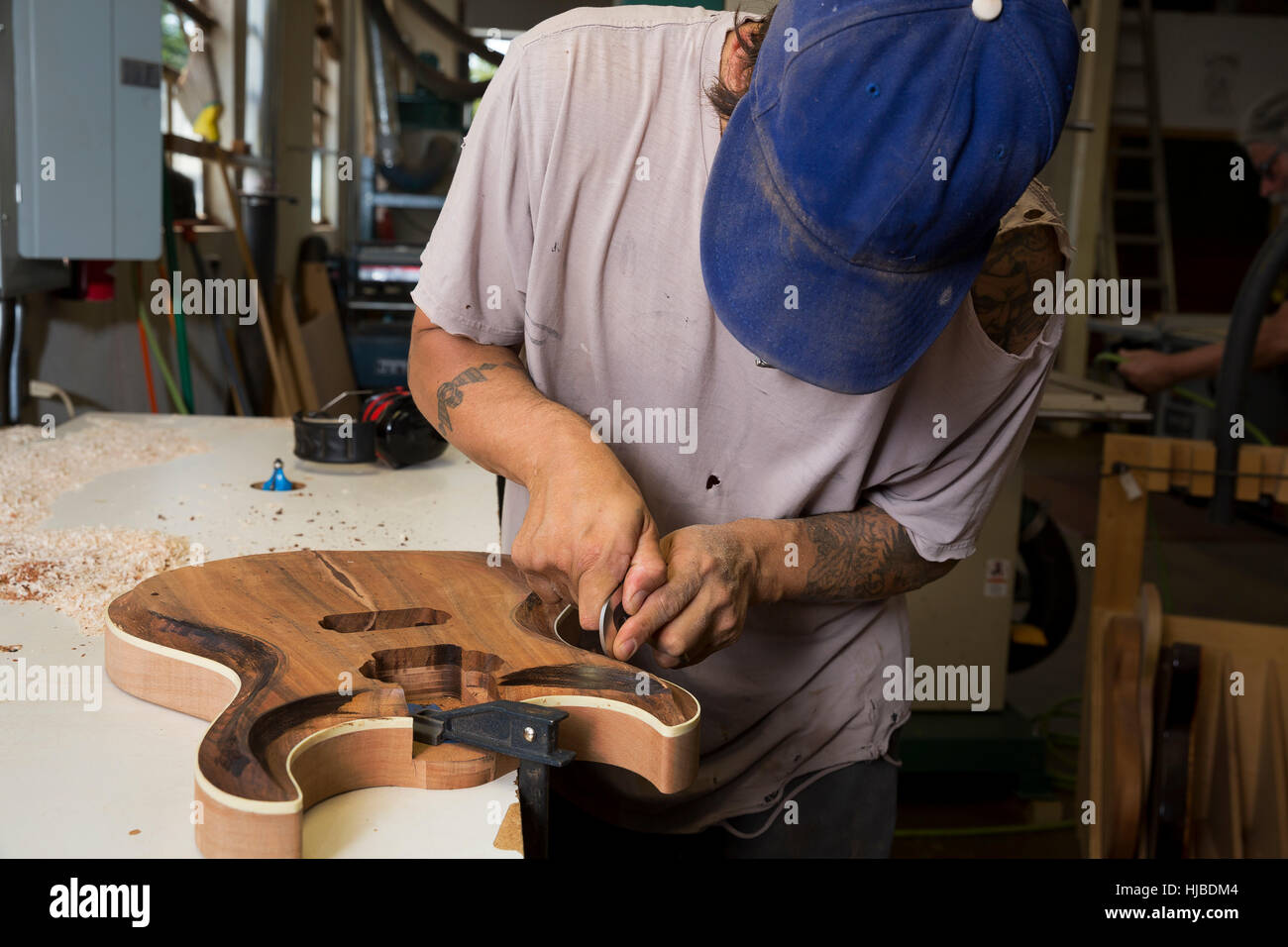 Guitar maker in workshop sanding guitar Stock Photo - Alamy