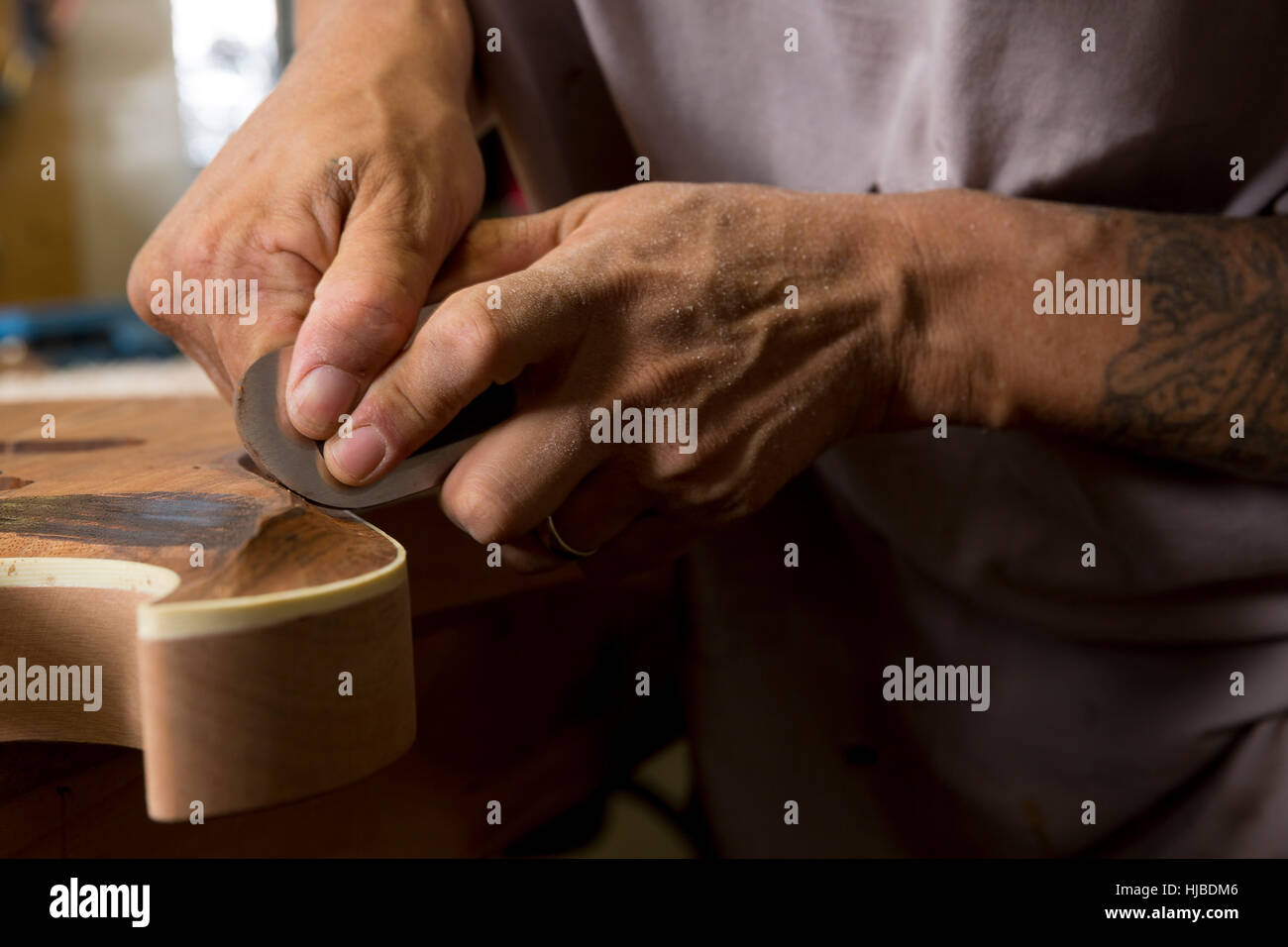 Guitar maker in workshop sanding guitar Stock Photo - Alamy