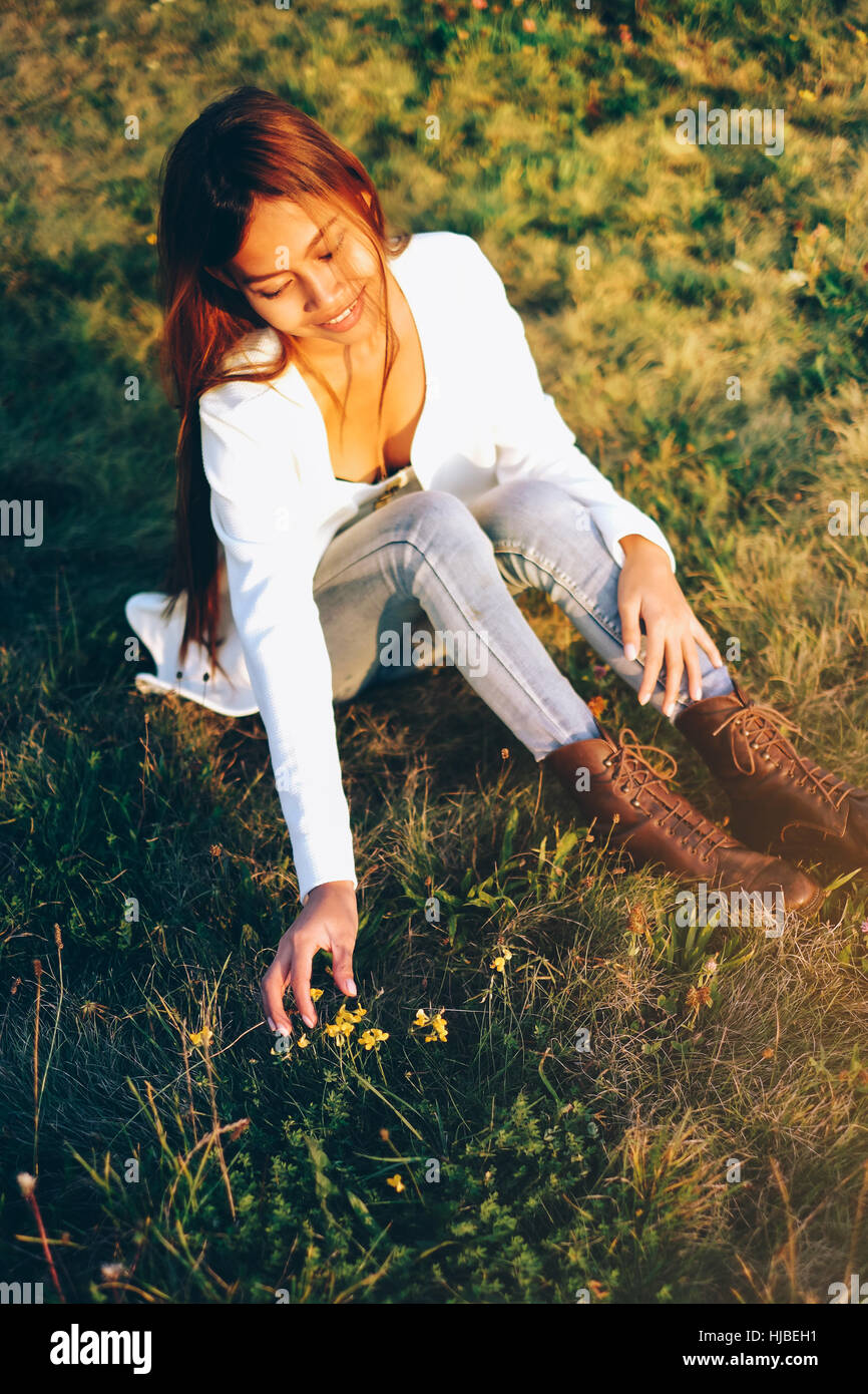 Young girl sitting on grass hi-res stock photography and images - Alamy