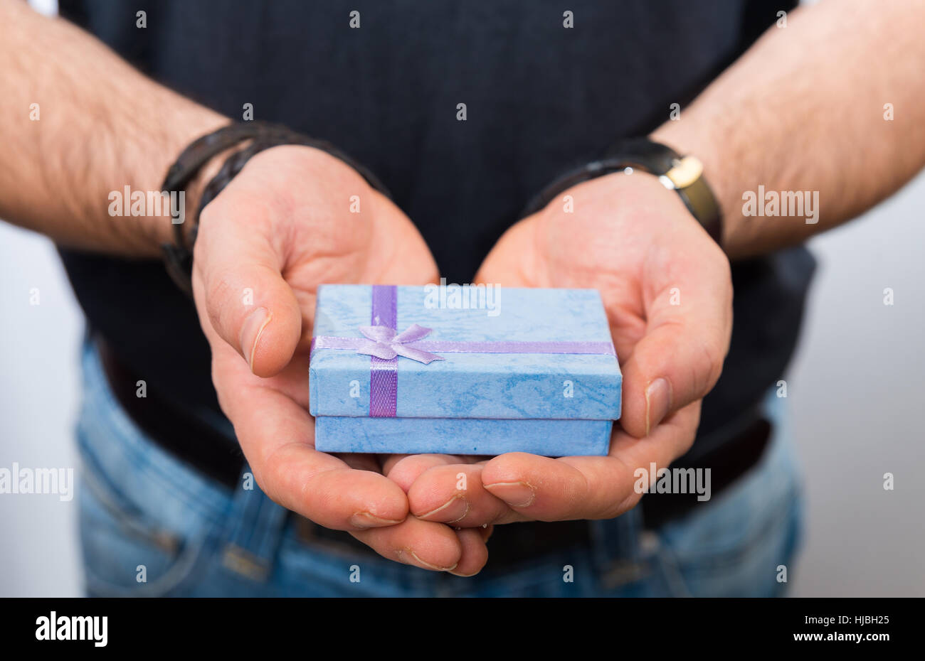 Men's hand holding gift box Stock Photo - Alamy