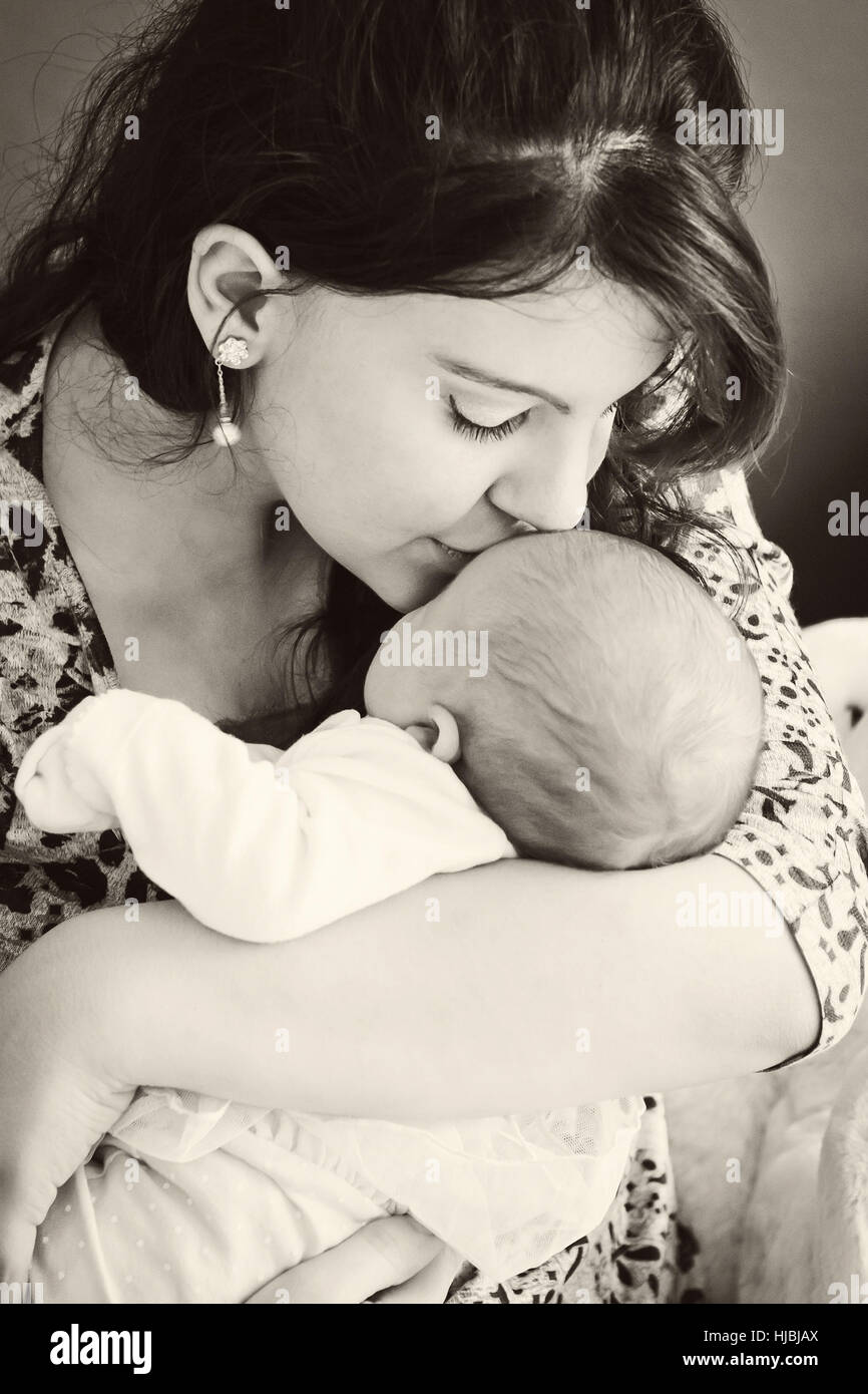 A young mother kissing her newborn baby BW Stock Photo - Alamy