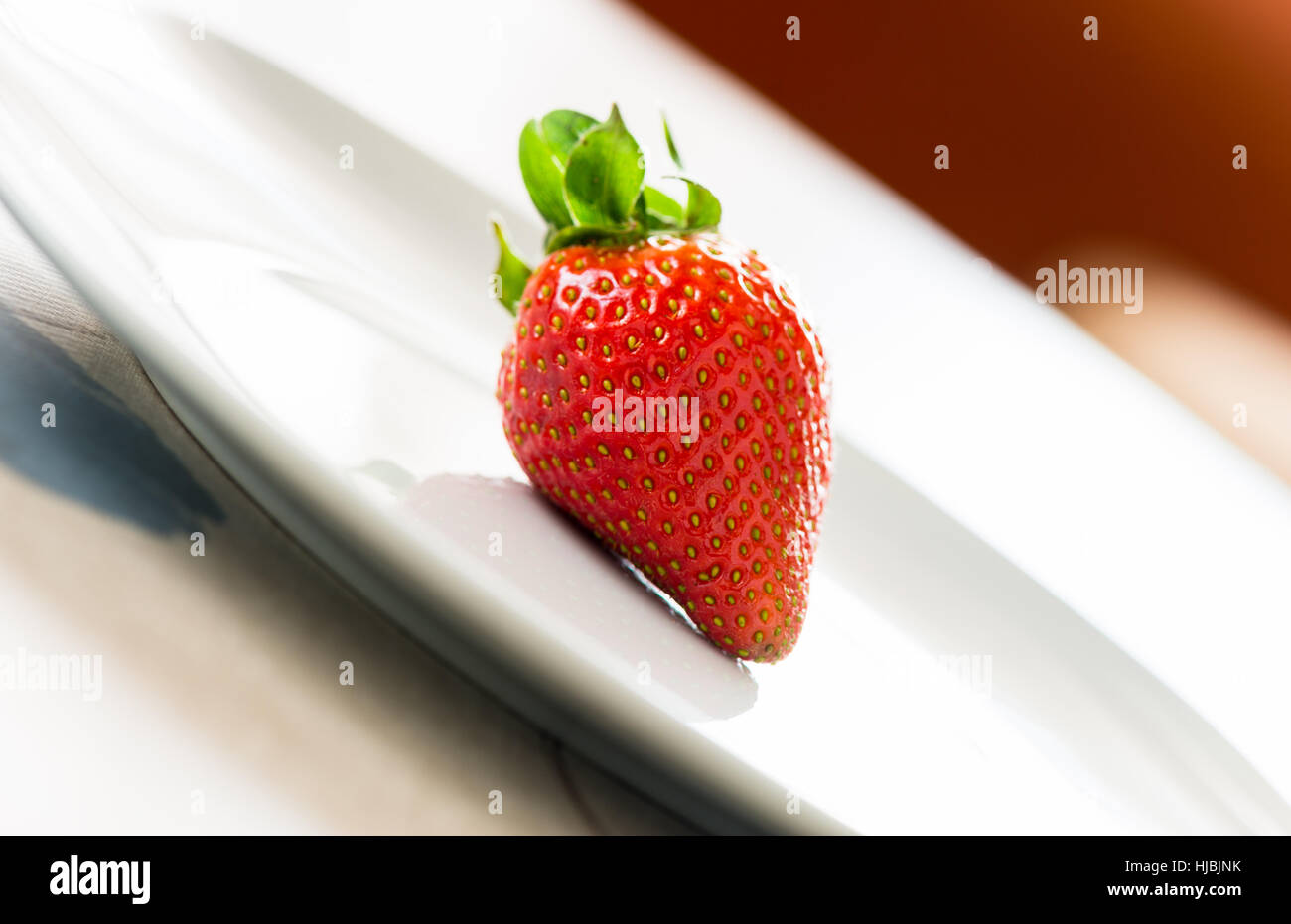 Single strawberry on a plate Stock Photo - Alamy