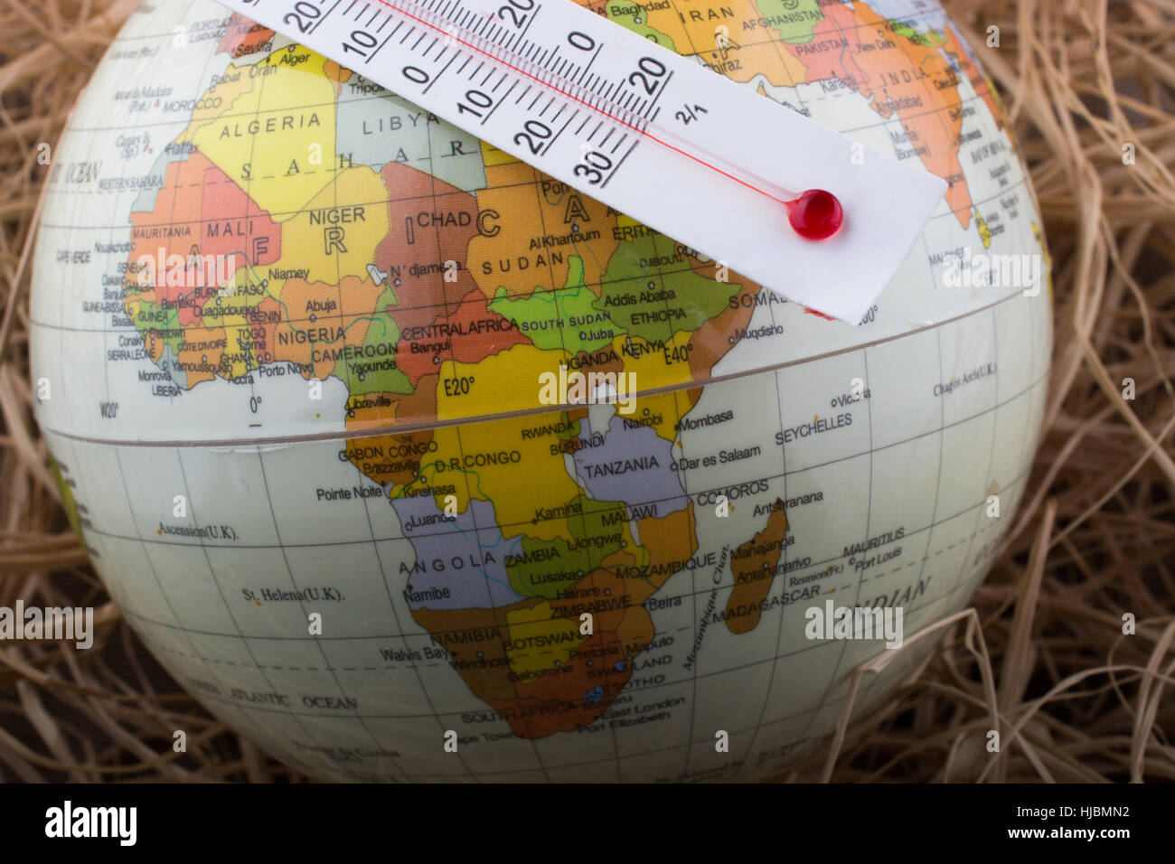 Thermometer placed on a little model globe Stock Photo - Alamy
