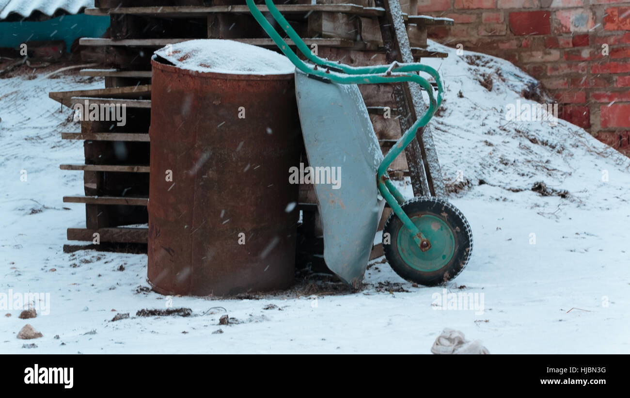 Cart rusty barrel and a stack of wooden pallets in the winter Stock ...