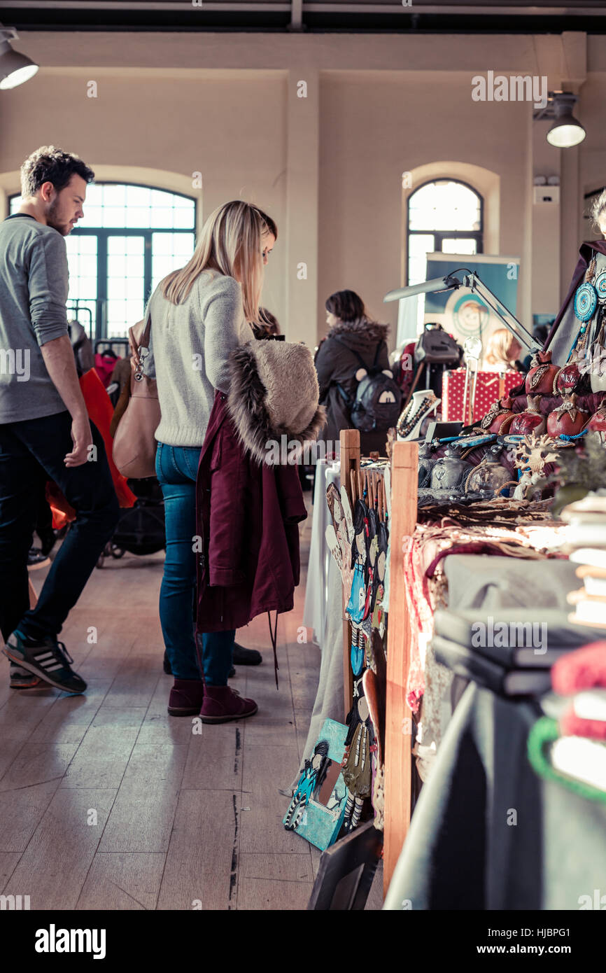 People buy and sell secondhand and handicraft items on indoor flea ...