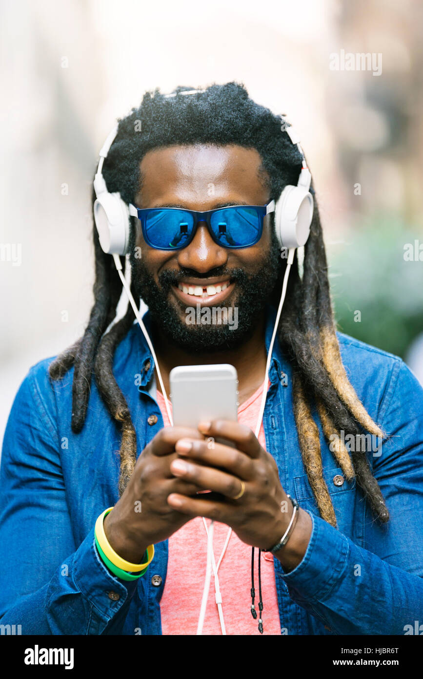African Young Man Using Mobile In The Street Stock Photo - Alamy