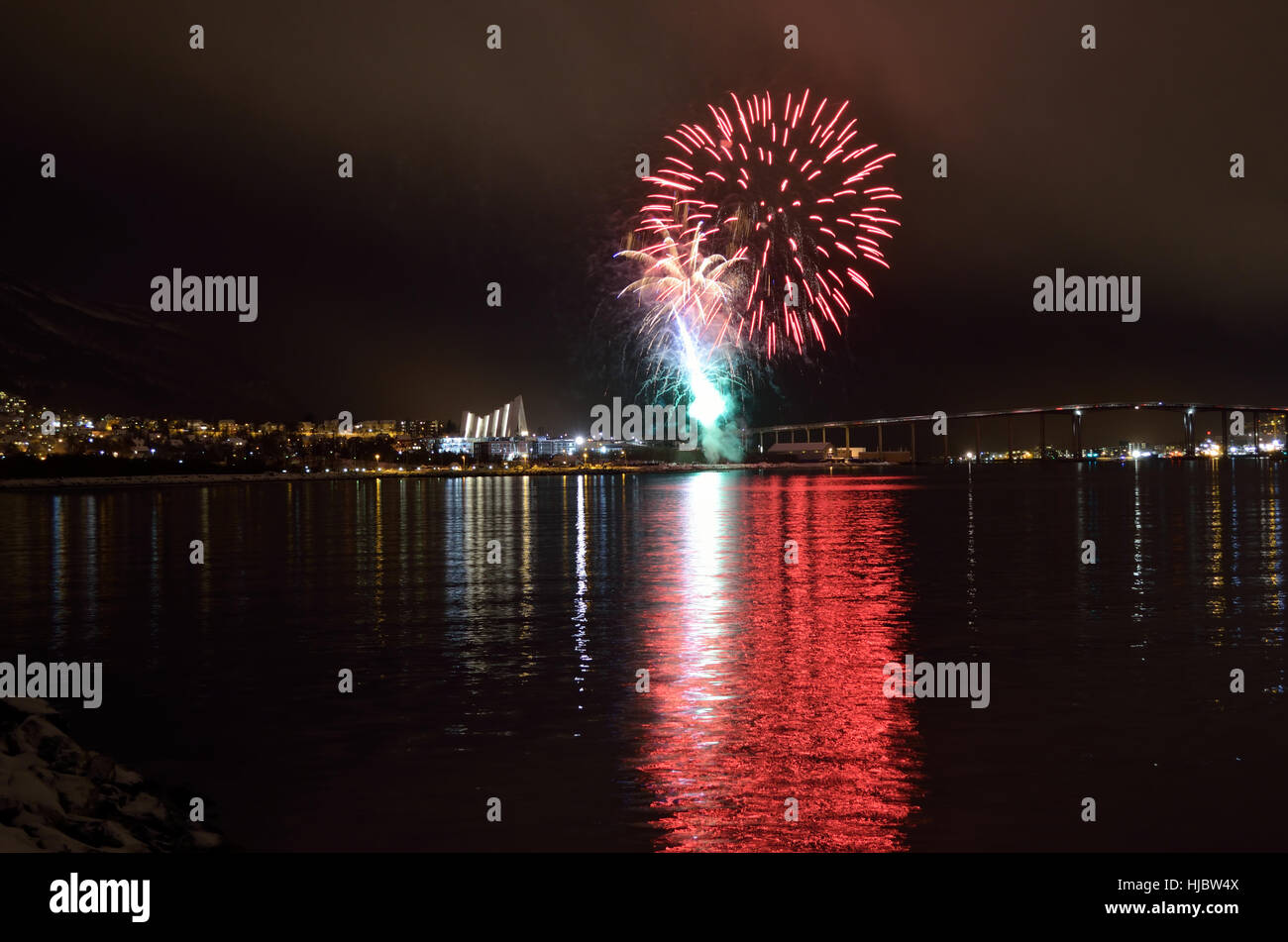 Beautiful firework on night sky in tromsoe city with bridge, cathedral ...