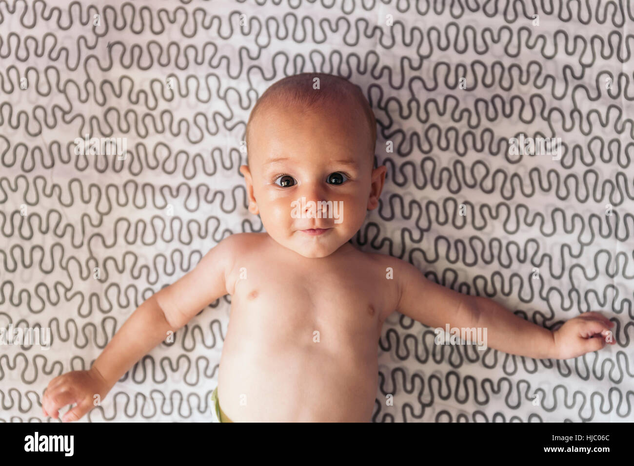 Beautiful expressive baby in the bed Stock Photo - Alamy