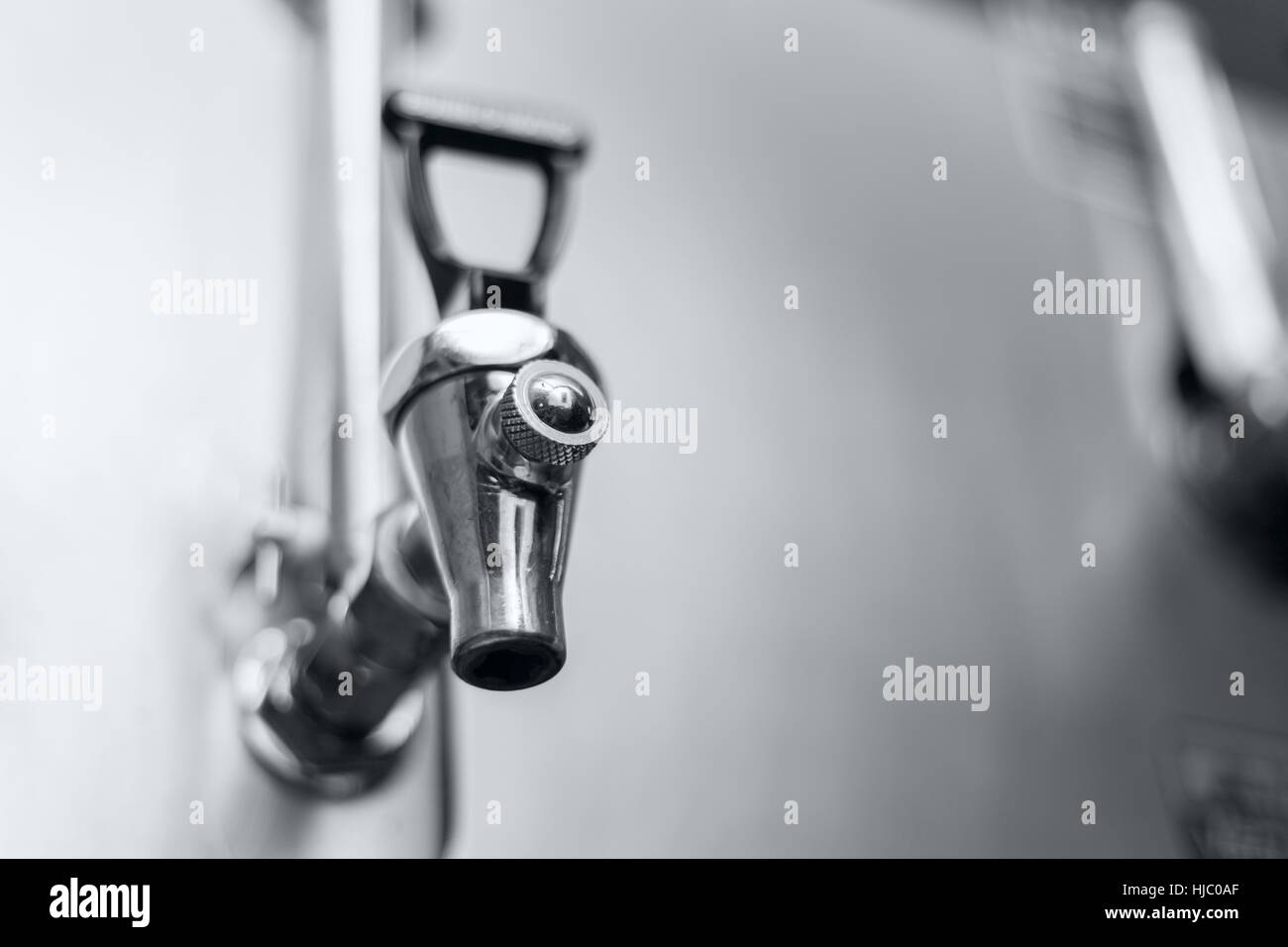 Big metal tap toned picture of a professional industrial coffee machine ...