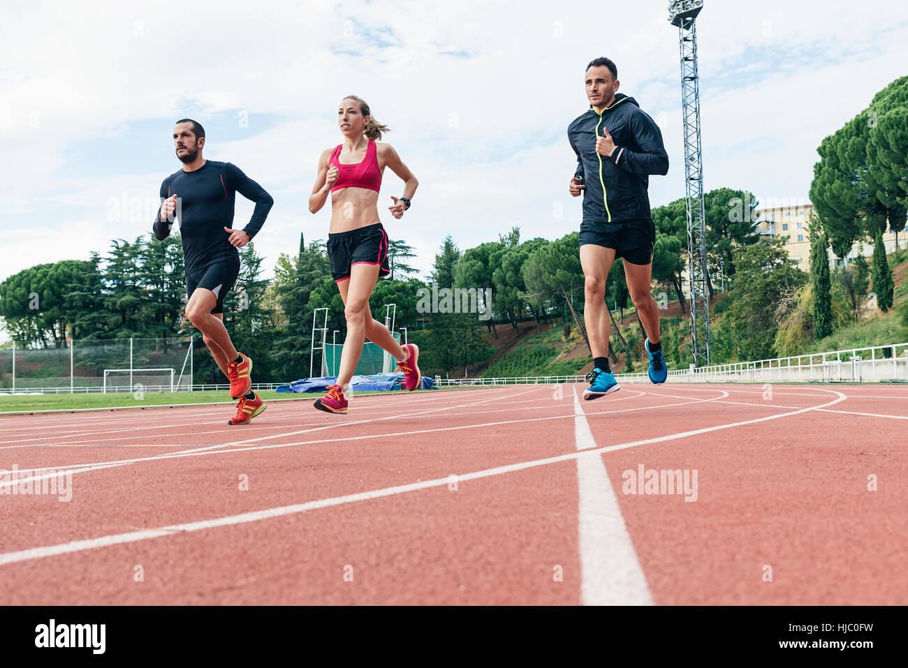 Group of young athletics people running on the track field Stock Photo ...