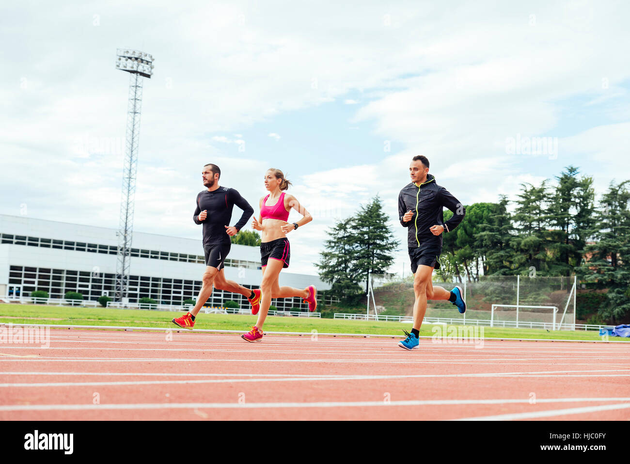 Group of young athletics people running on the track field Stock Photo ...