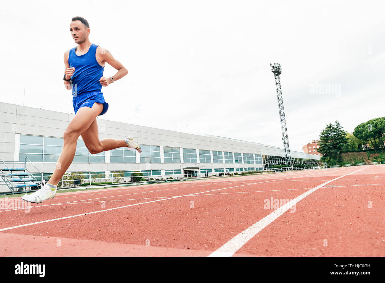 Attractive man Track Athlete Running On Track. He is on stadium Stock ...