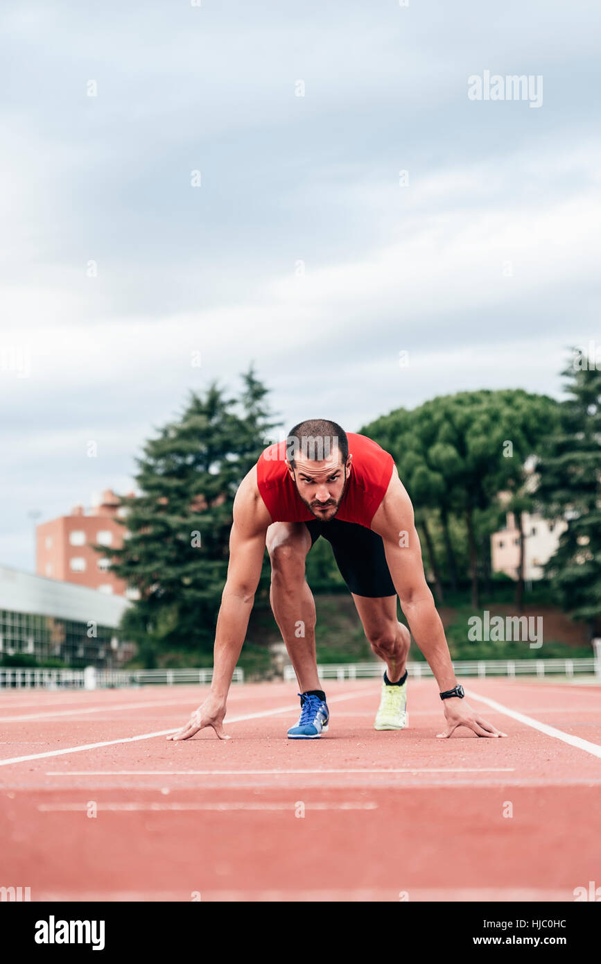 Man getting ready to start running on Stadium Stock Photo - Alamy
