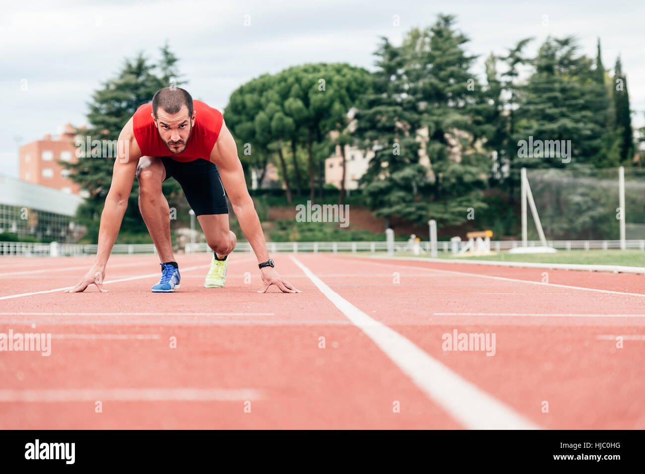 Man getting ready to start running on Stadium Stock Photo - Alamy