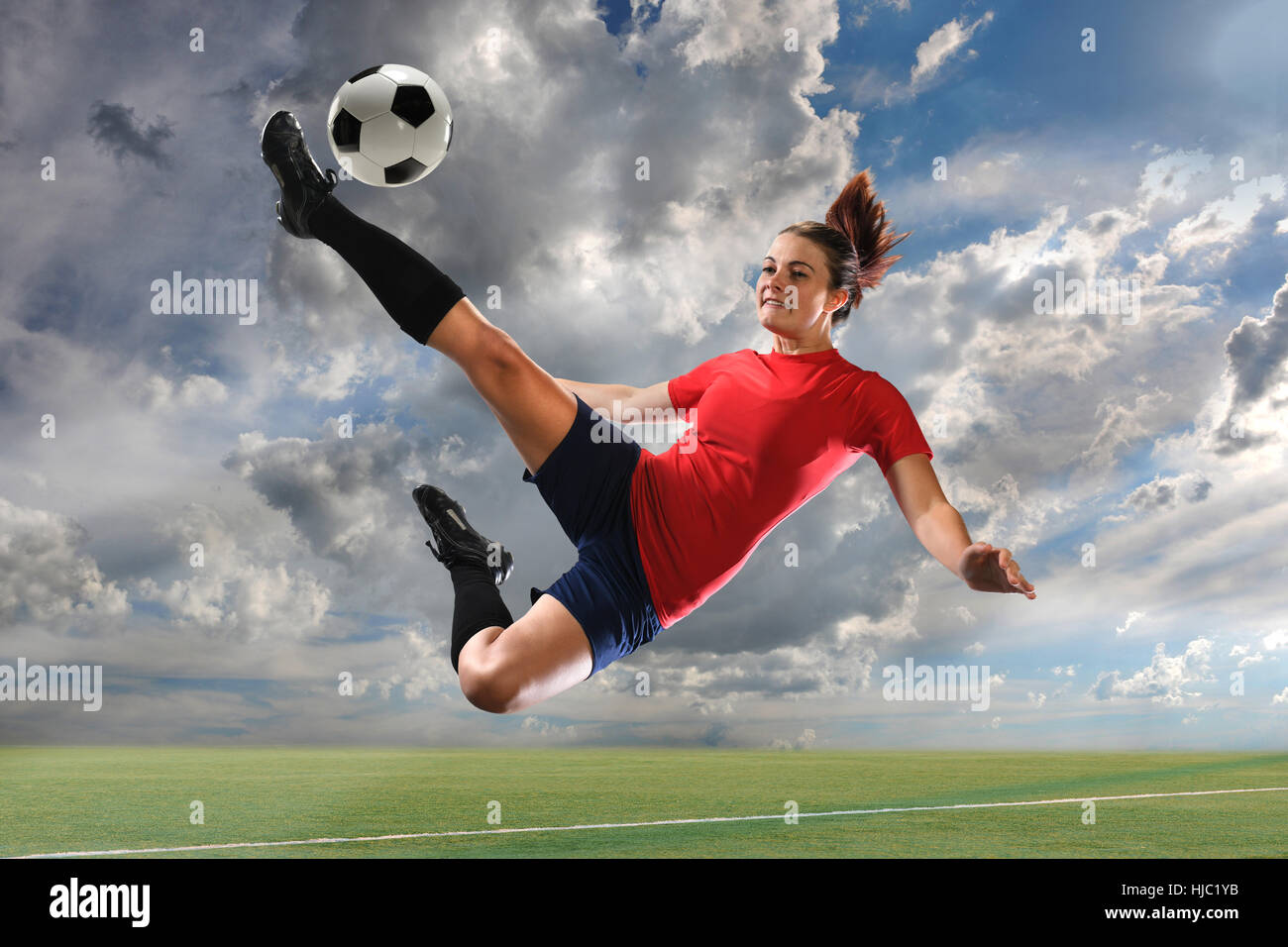 Female soccer player kicking ball outdoors Stock Photo - Alamy