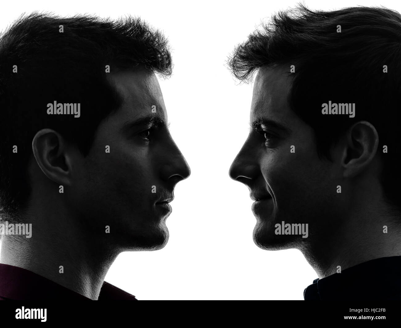 close up portrait two caucasian young men in shadow white background ...