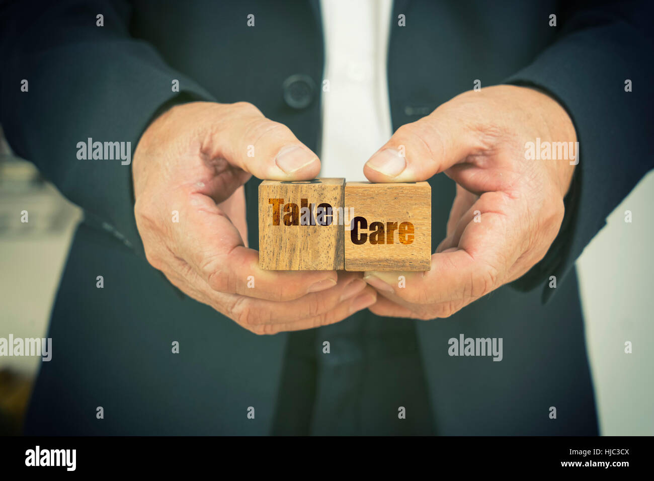 abstract take care word on wood block on businessman hand - can use to ...
