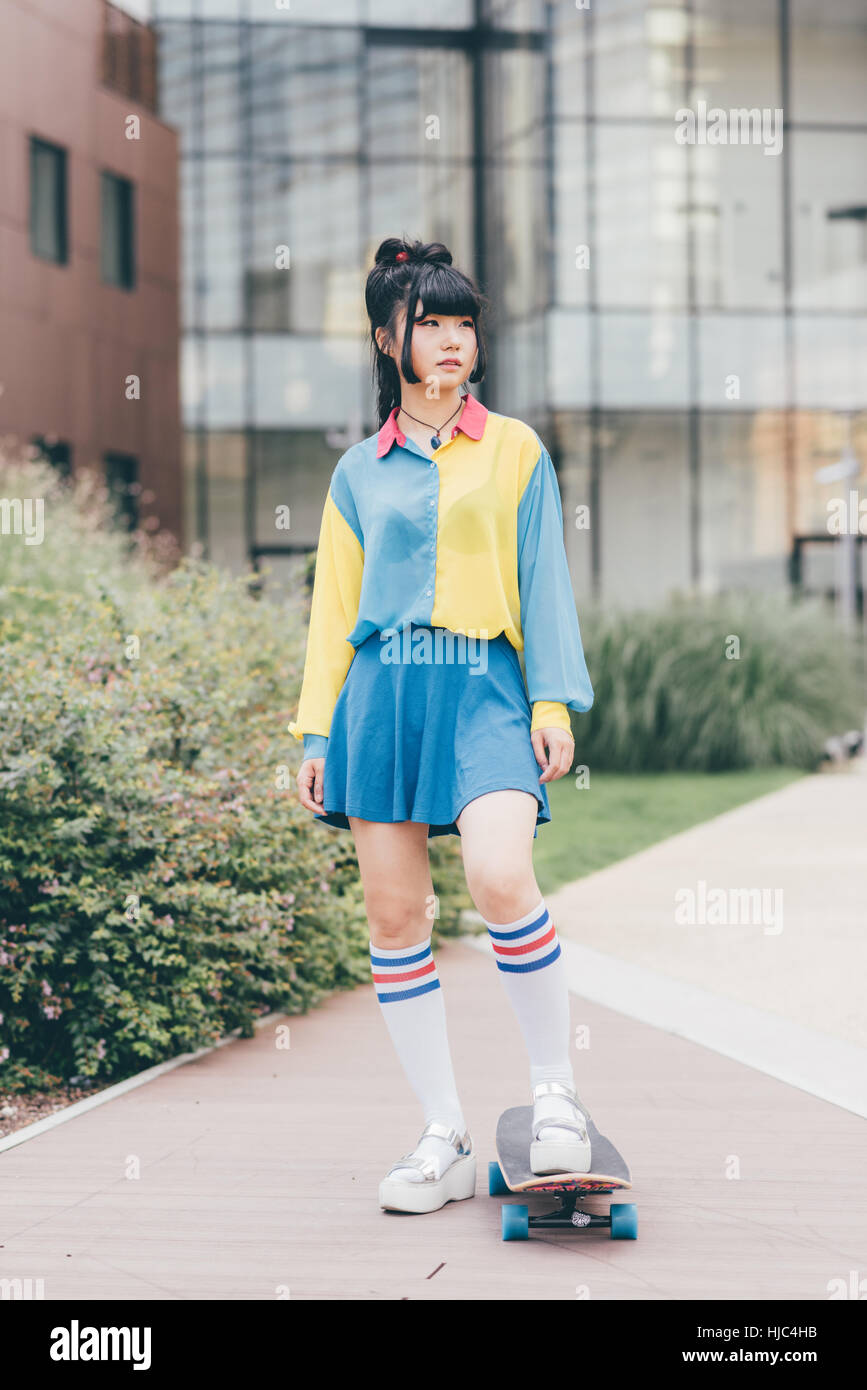 young beautiful asian millennial woman nonconformist skating outdoor in the city - skater ...