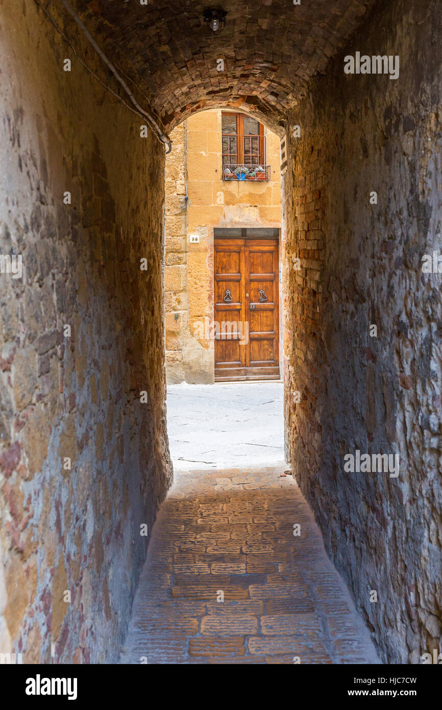 Dark narrow alley with a door at the end Stock Photo - Alamy
