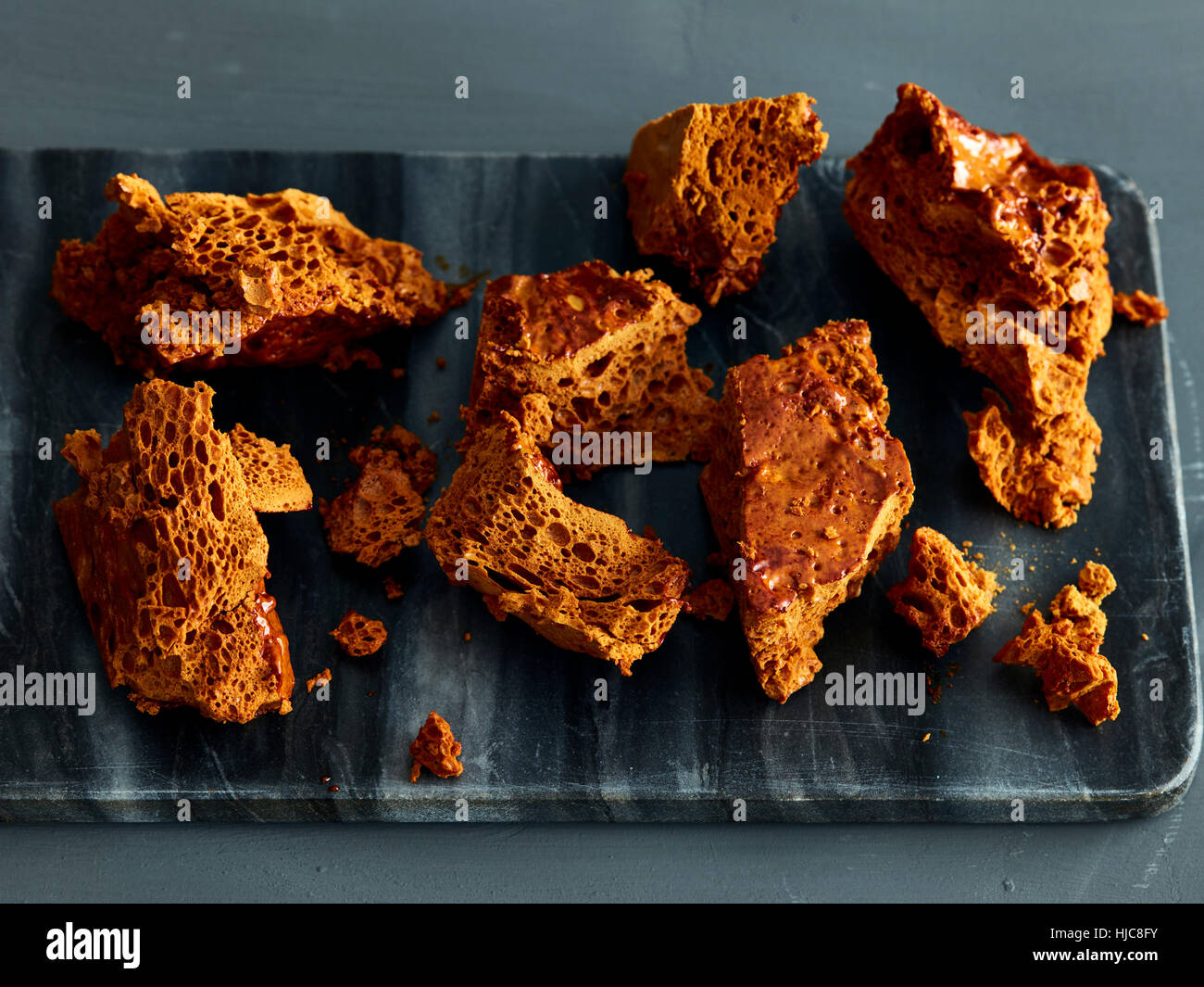 Broken honeycomb toffee on marble cutting board Stock Photo - Alamy