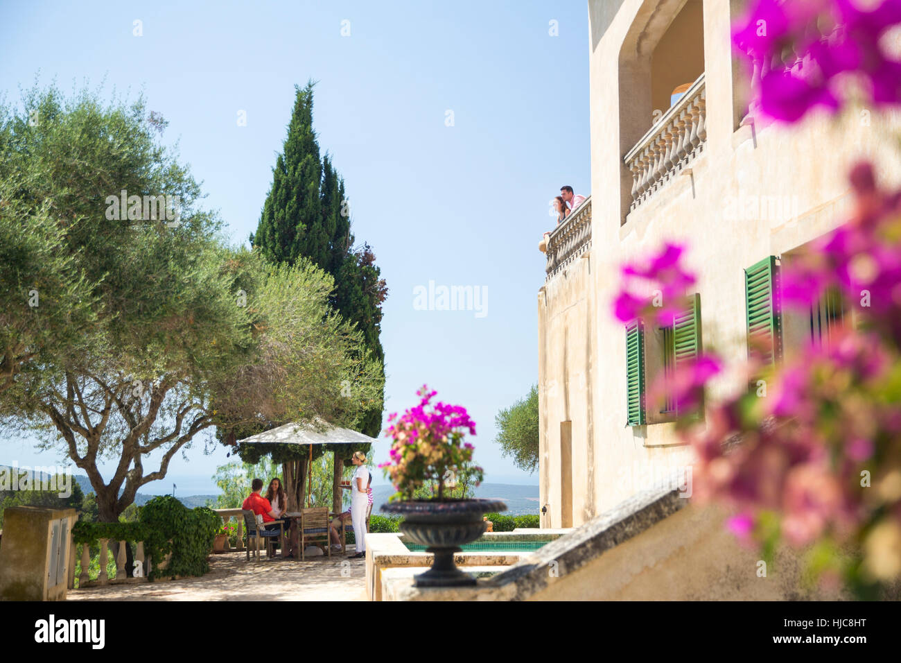 Guests and waitress serving outside boutique hotel, Majorca, Spain ...