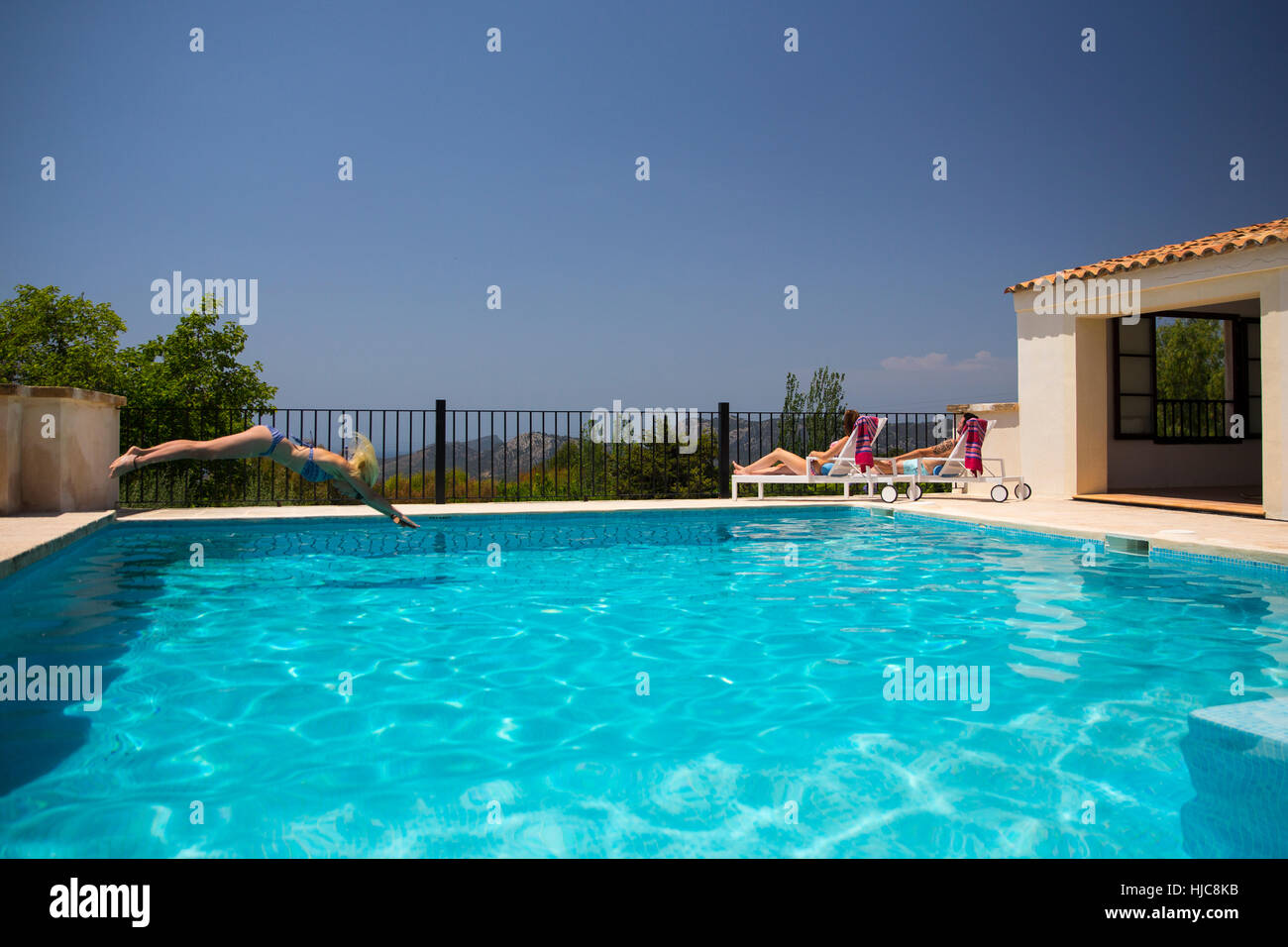 Young woman diving into boutique hotel swimming pool, Majorca, Spain ...