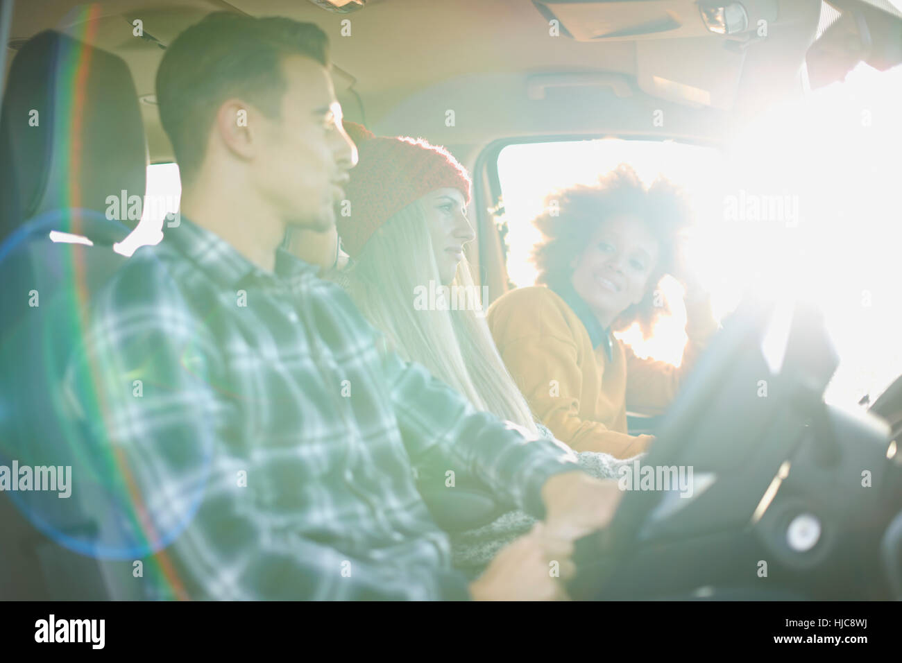 Three young adult friends driving in sunlit car Stock Photo - Alamy