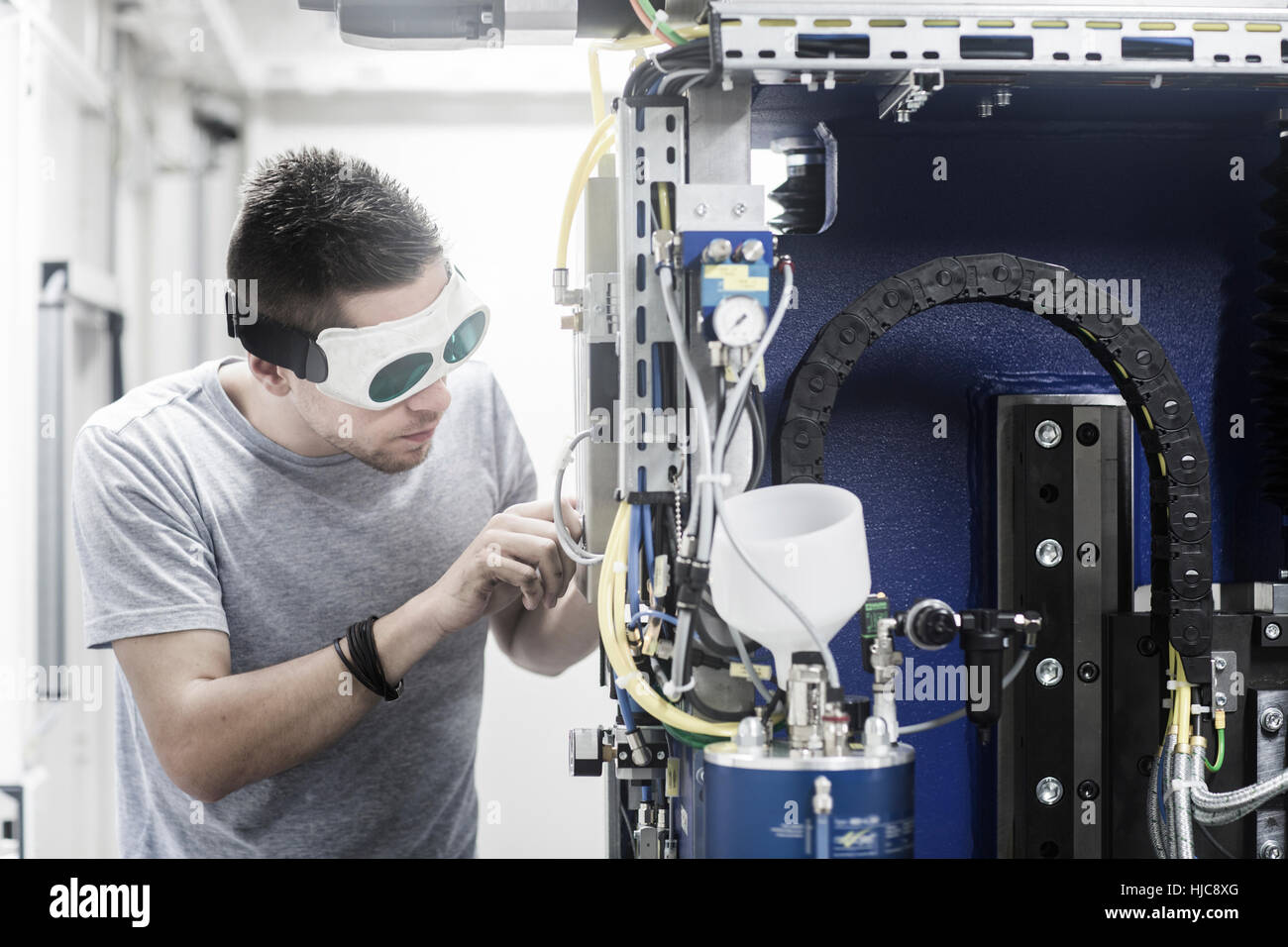 Engineer, wearing safety goggles, working in engineering plant Stock ...