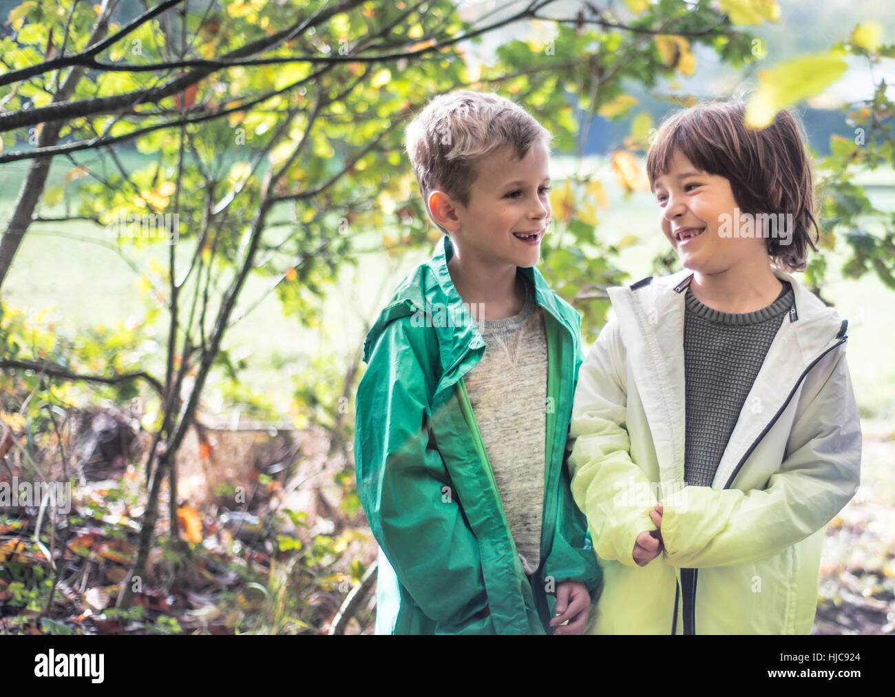 Two boys in park, standing together, laughing Stock Photo - Alamy