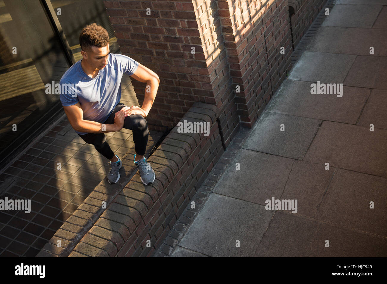 Man stretching beside column Stock Photo - Alamy