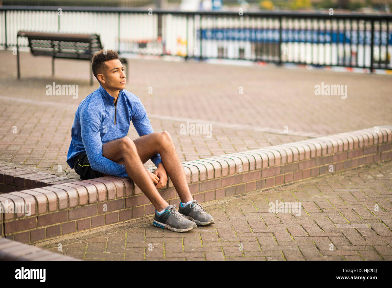 Young man sitting on sidewalk pavement hi-res stock photography and ...