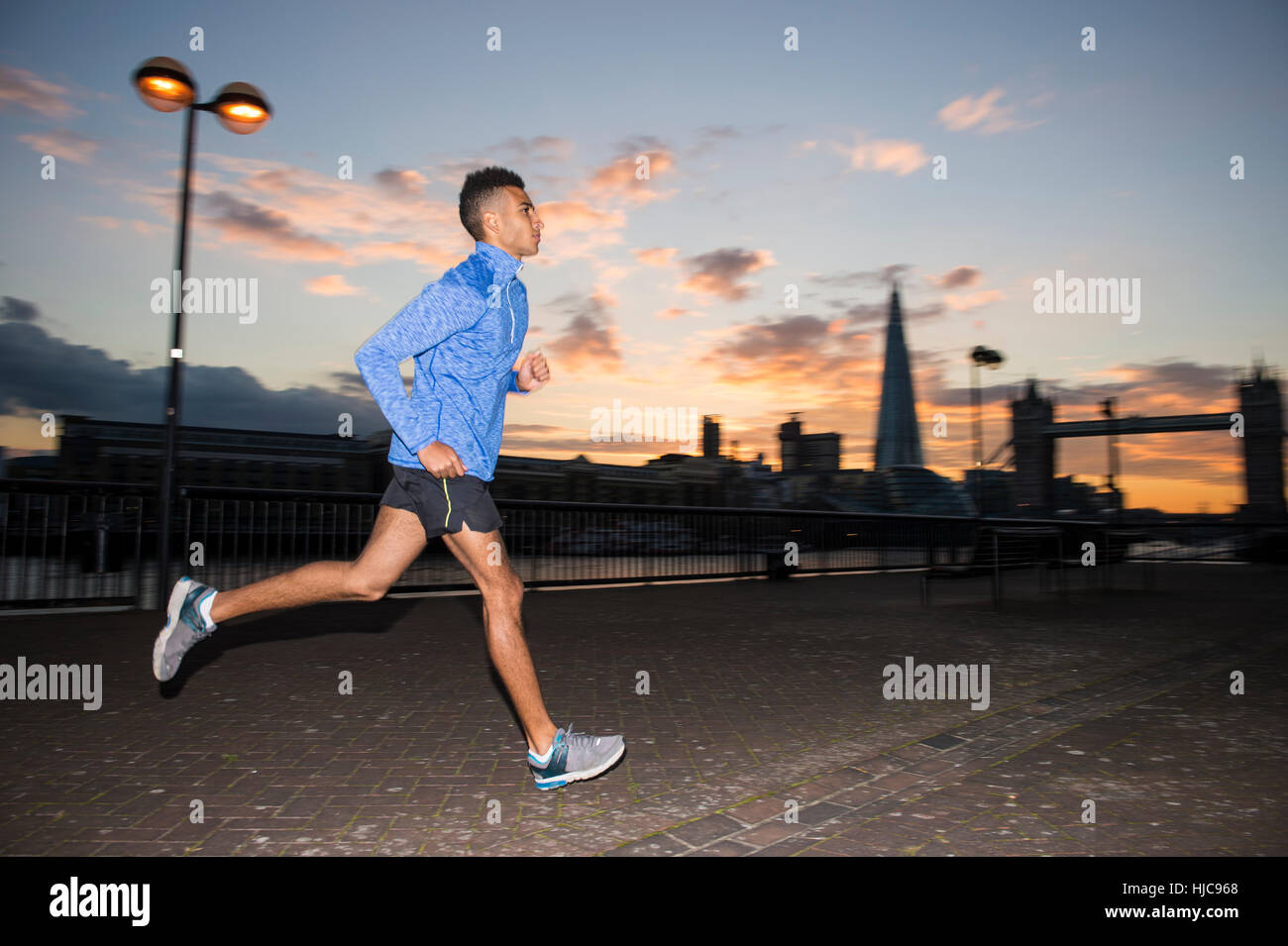 Man running, Tower Bridge and The Shard in background, Wapping, London ...