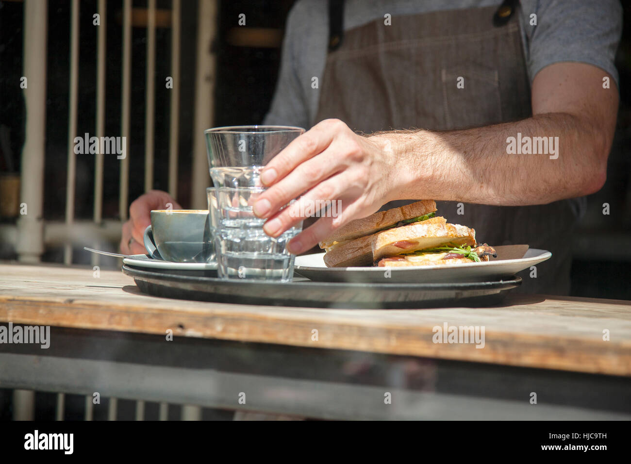 Cropped shot of waiter preparing order at cafe window Stock Photo - Alamy