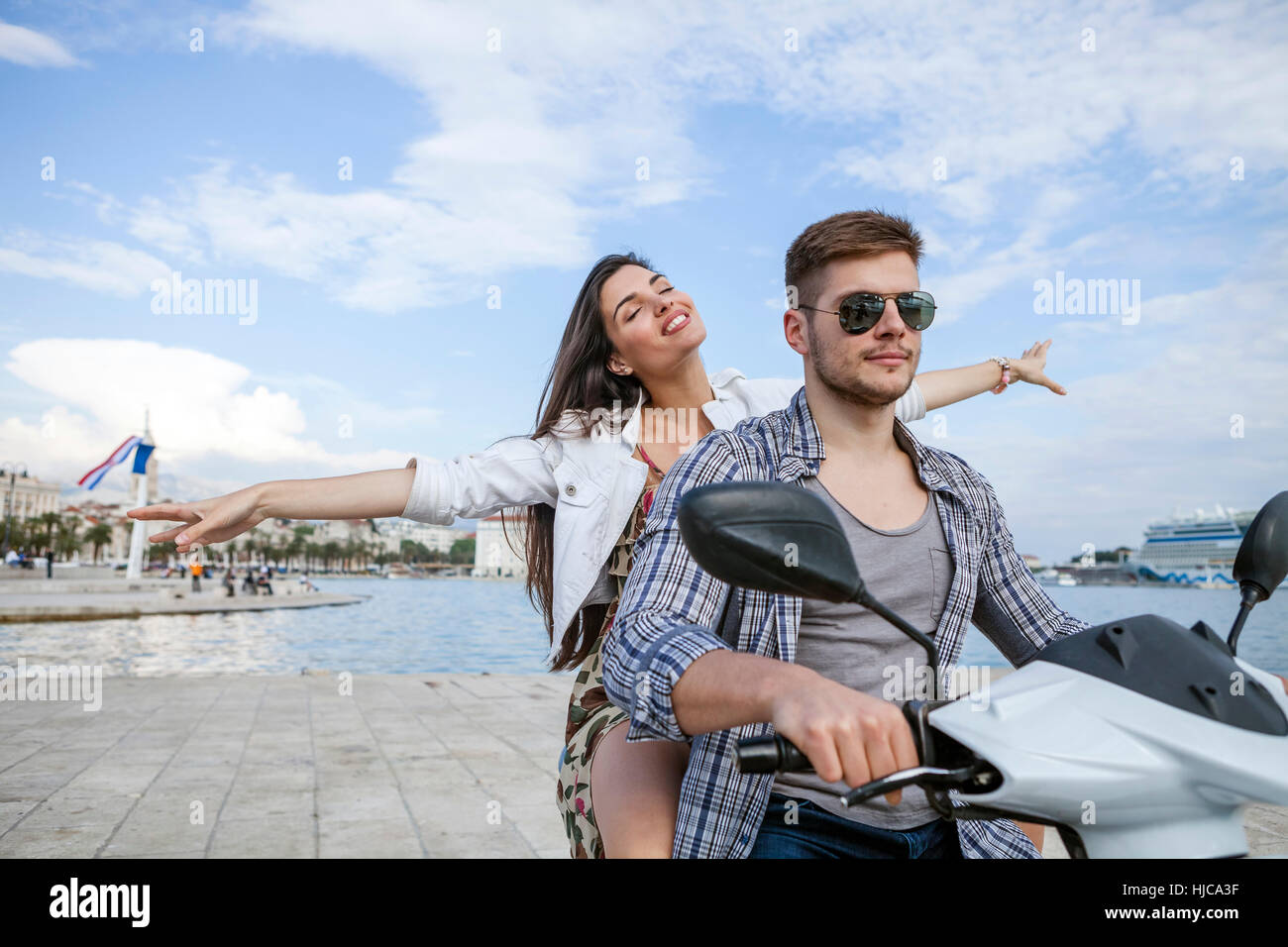 Young couple riding moped at harbour, Split, Dalmatia, Croatia Stock ...