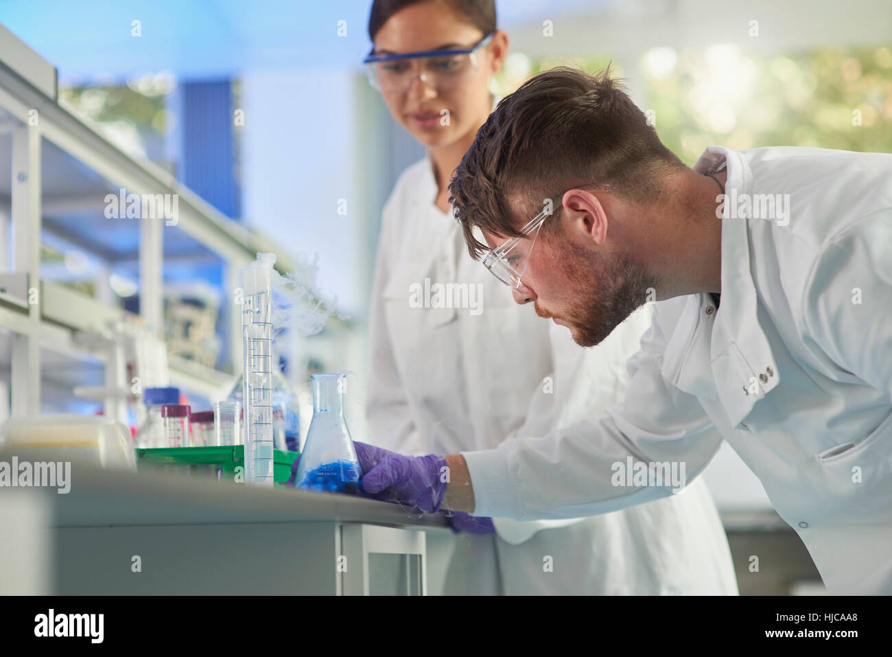 Scientist examining conical flask Stock Photo - Alamy