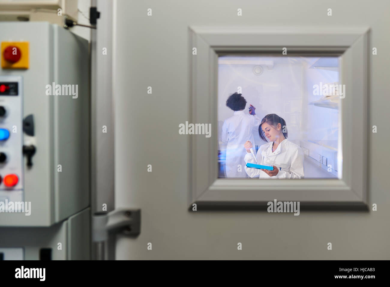 View through window of scientists in laboratory Stock Photo - Alamy