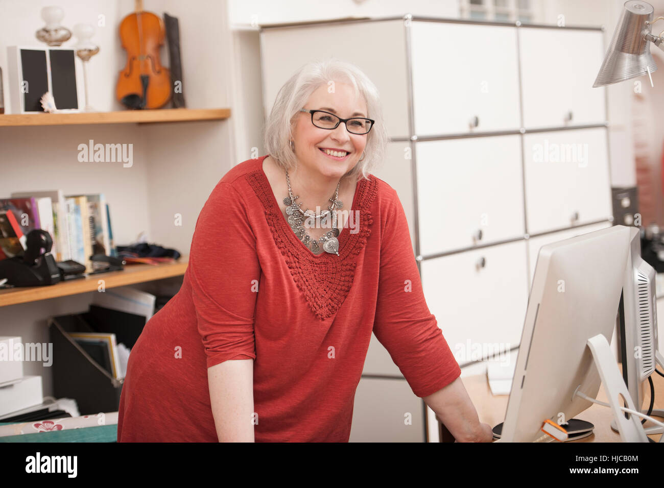 Woman smiling at work desk Stock Photo - Alamy