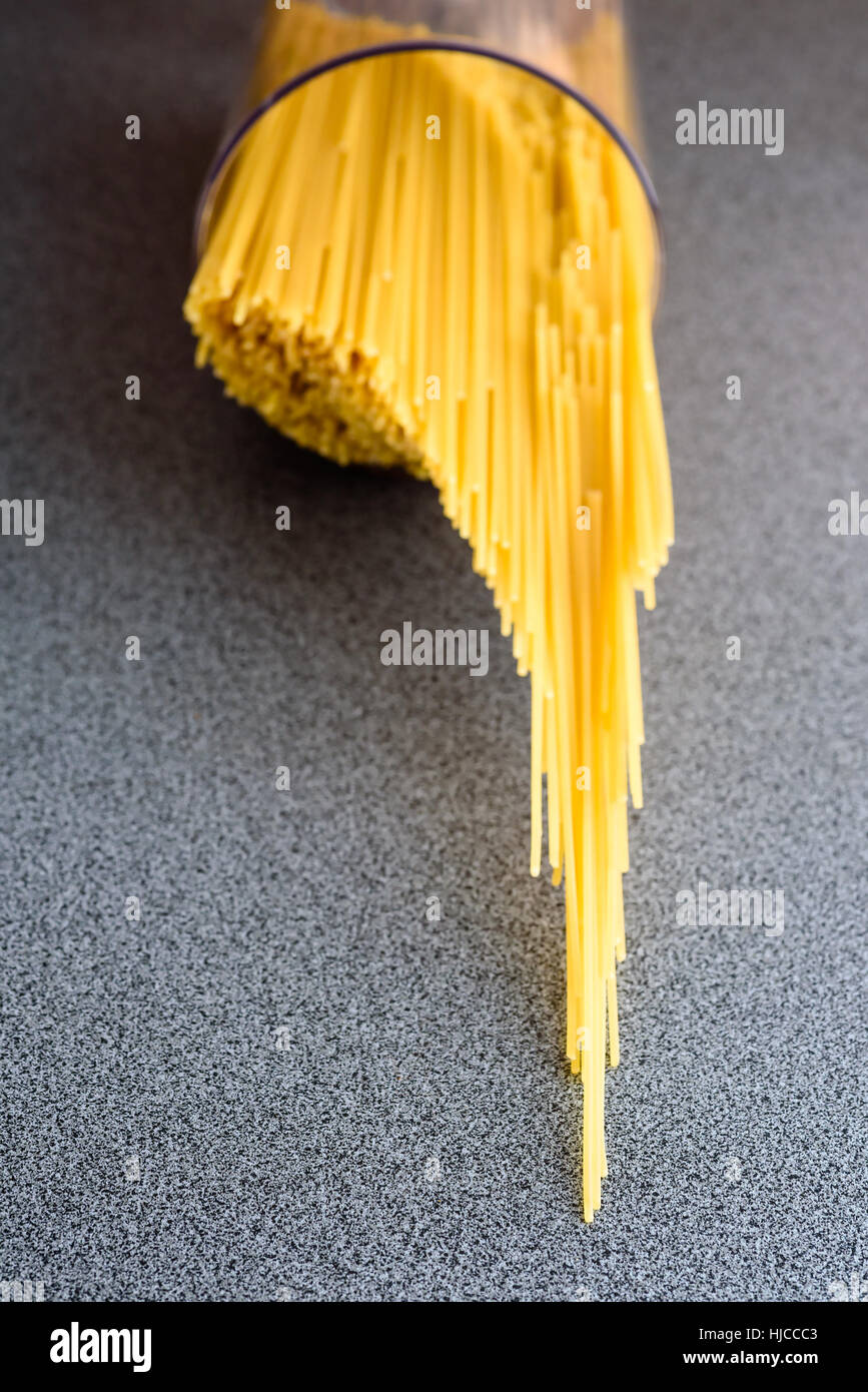 Dry and uncooked spaghetti spilling out of its transparent plastic ...