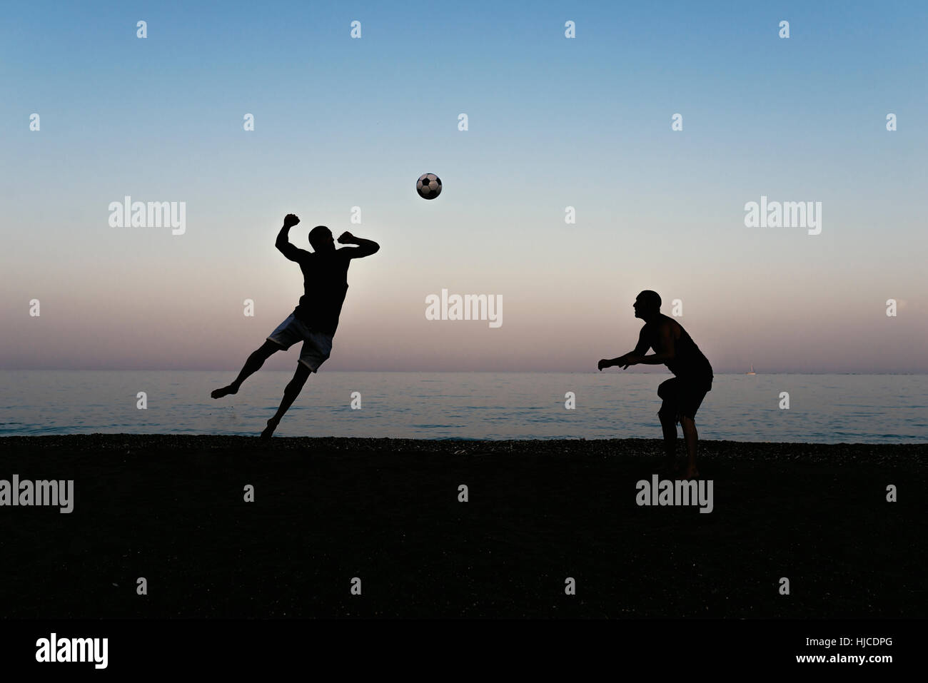 Two friends playing soccer in the beach Stock Photo - Alamy