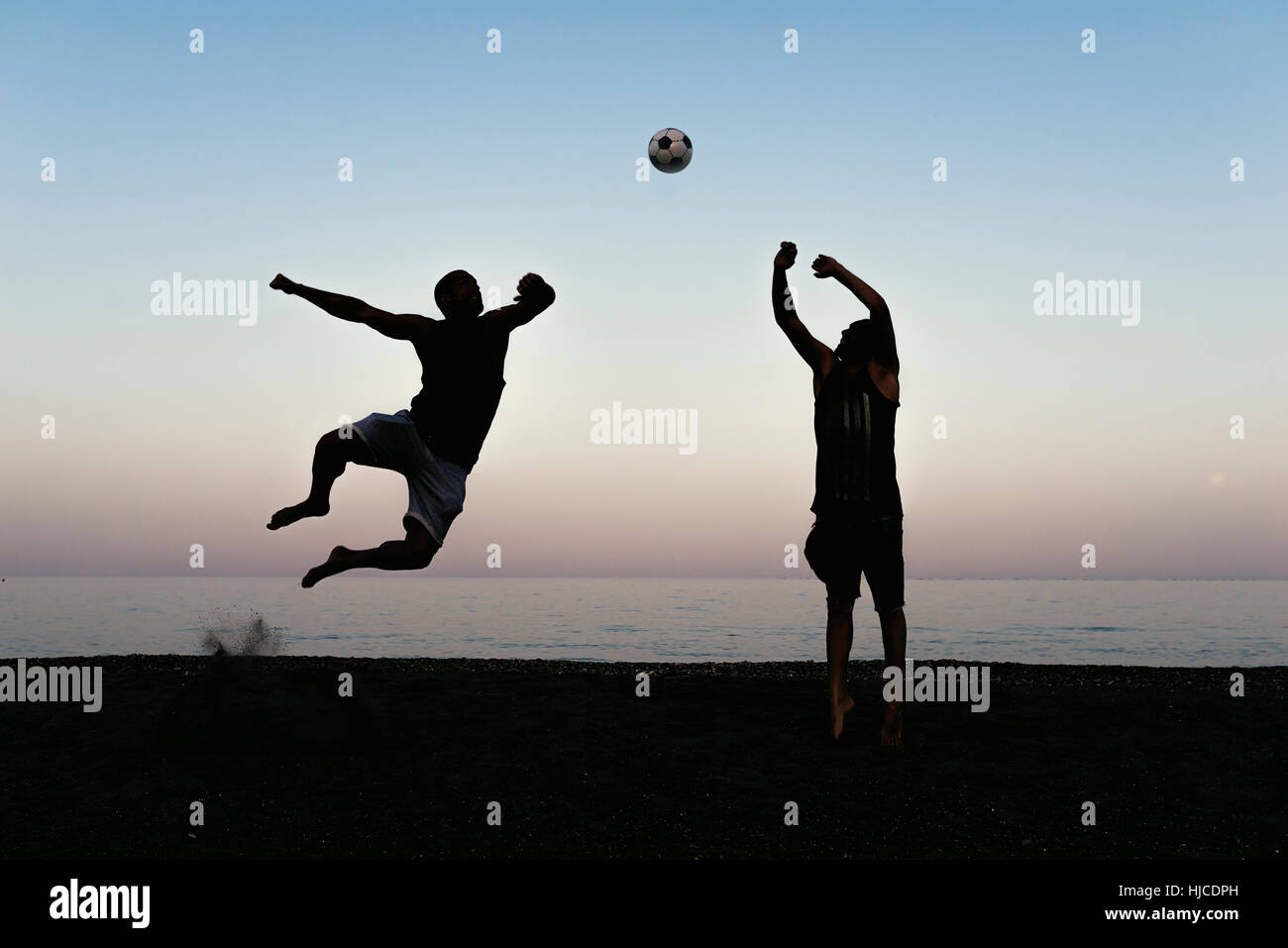 Two friends playing soccer in the beach Stock Photo - Alamy