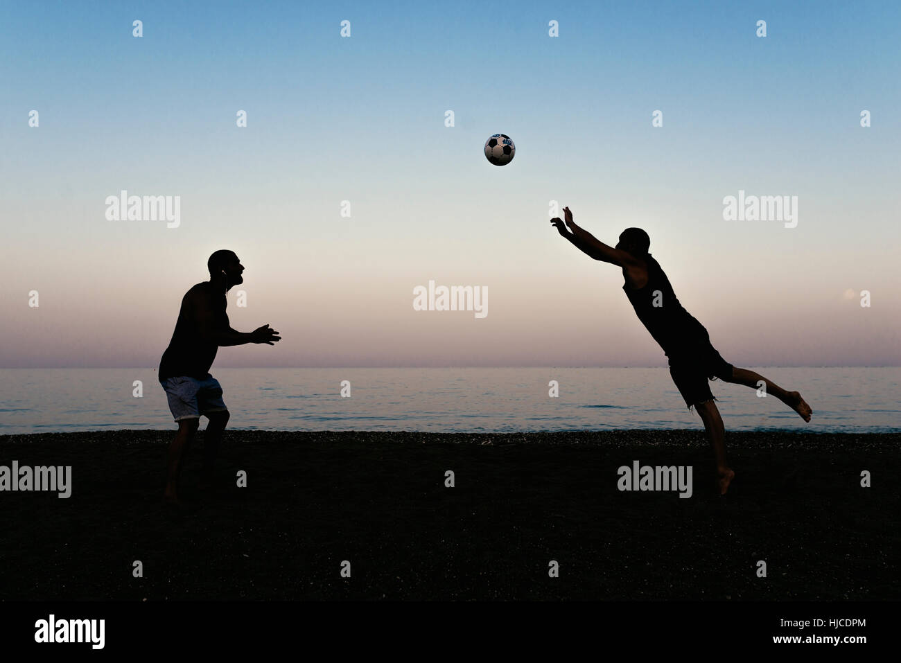 Two friends playing soccer in the beach Stock Photo - Alamy