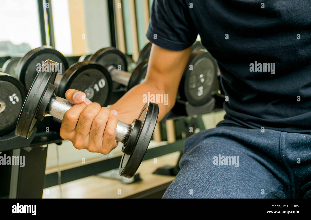 man is exercise with dumbbell in the gym Stock Photo - Alamy