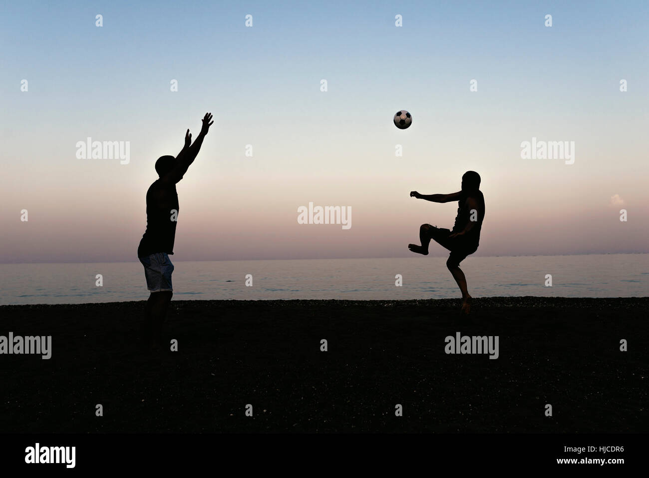 Two friends playing soccer in the beach Stock Photo - Alamy