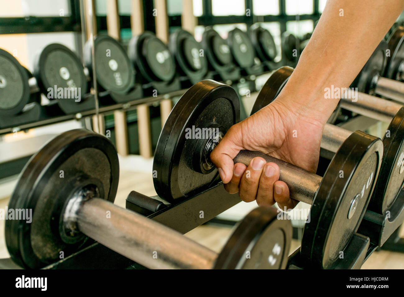 man is exercise with dumbbell in the gym Stock Photo - Alamy